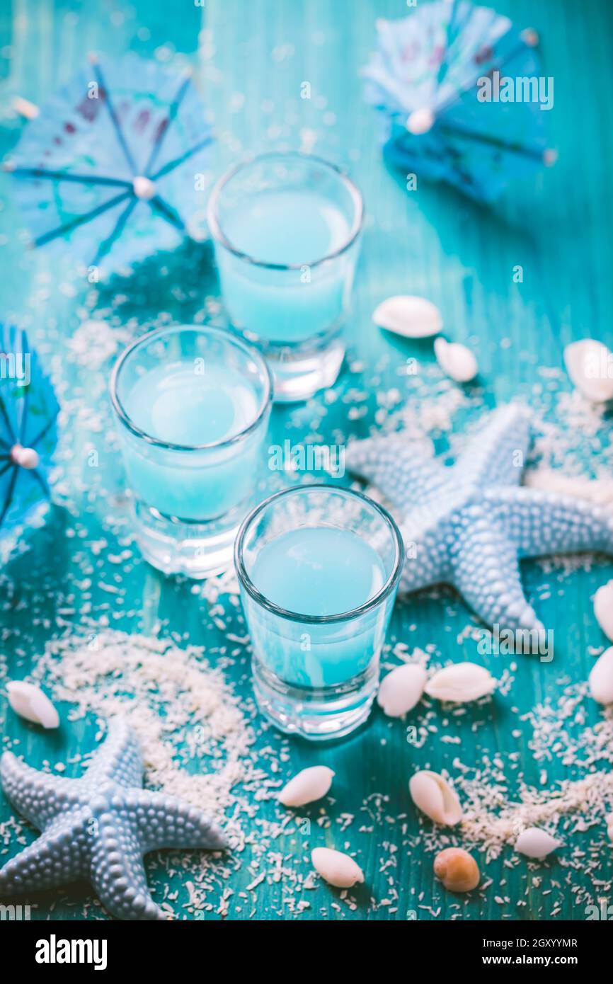 Blue shots for summer with seashells on blue background. Small ...
