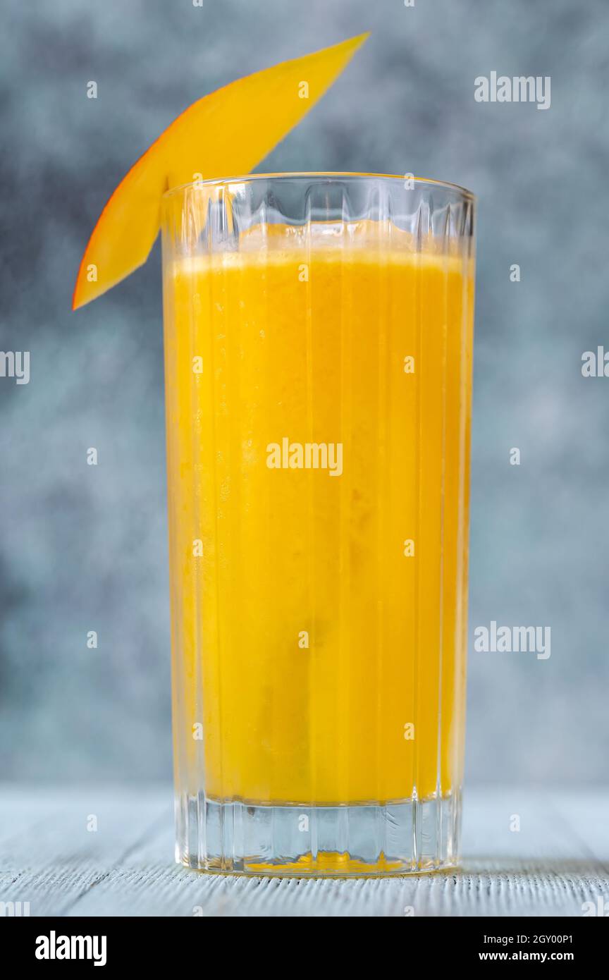 Glass of Mango Rum Cooler cocktail garnished with slice of fresh mango ...