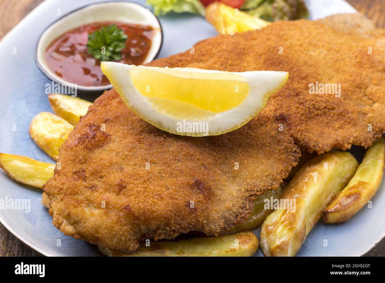 wiener schnitzel with fries on a plate Stock Photo - Alamy