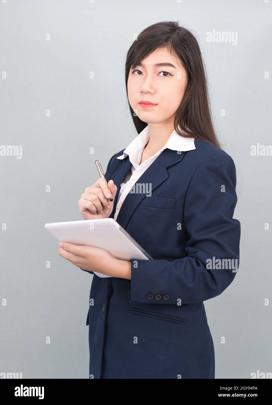 Woman in suit using computer digital tablet isolate on gray background ...