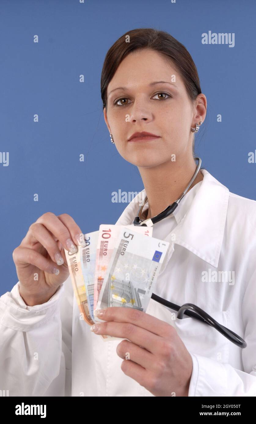 young female doctor with stethoscope showing money Stock Photo - Alamy