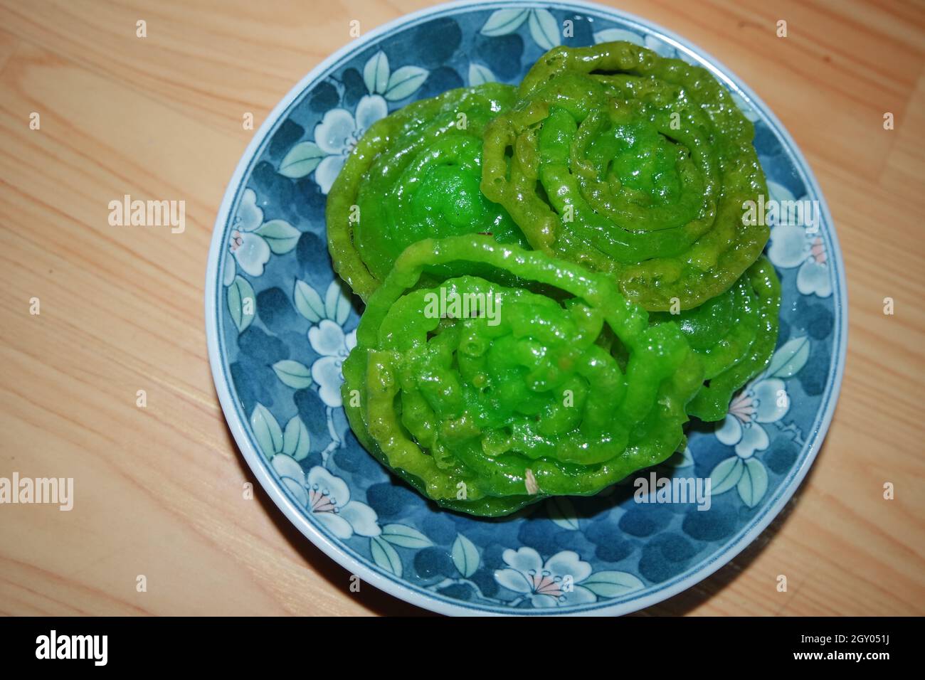 Crispy sweet Asian dessert green Jalebi cooked and served in ceramic ...