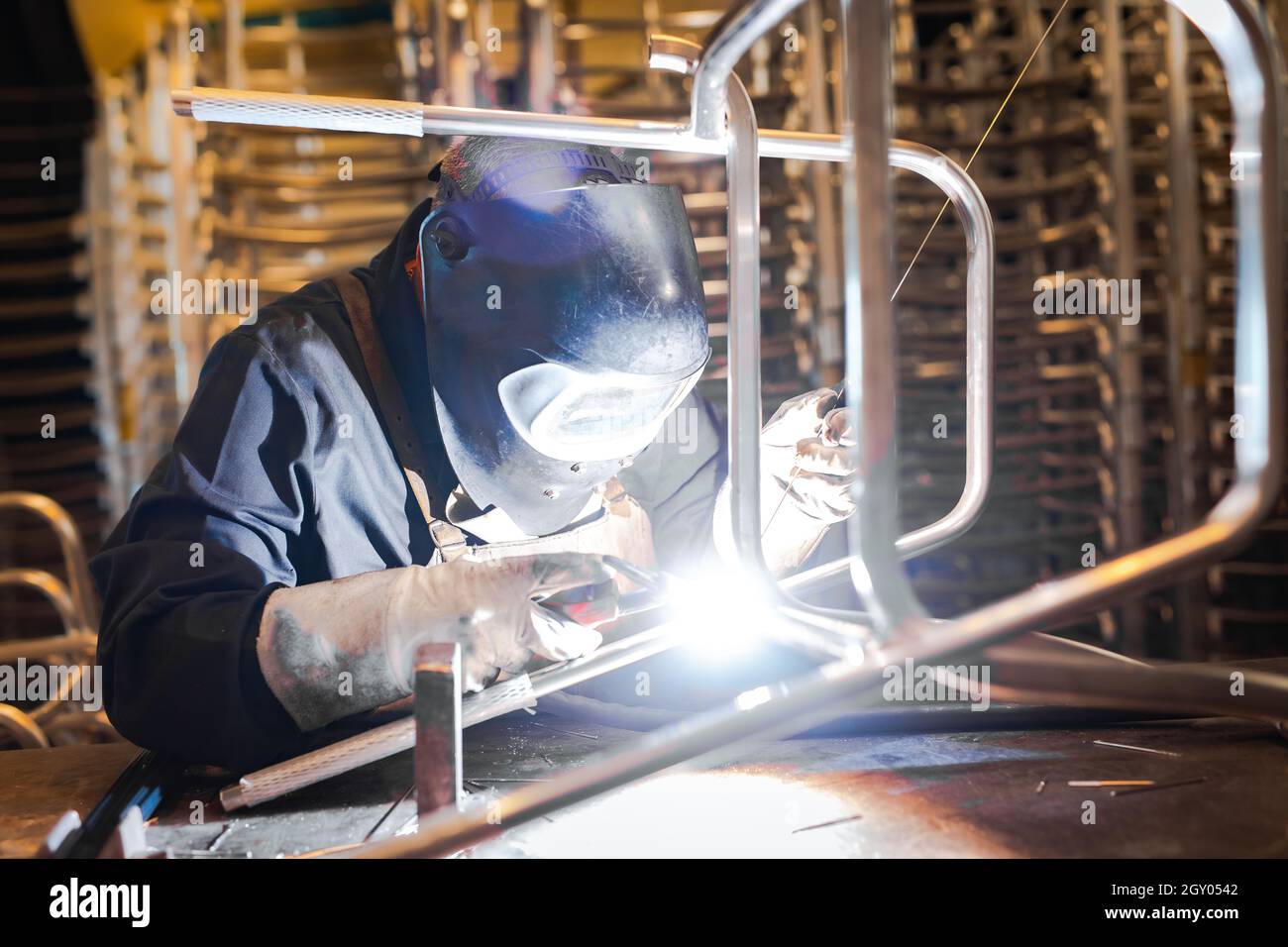 Welder erecting steel in a manufacturing factory. Metalwork craftsman ...