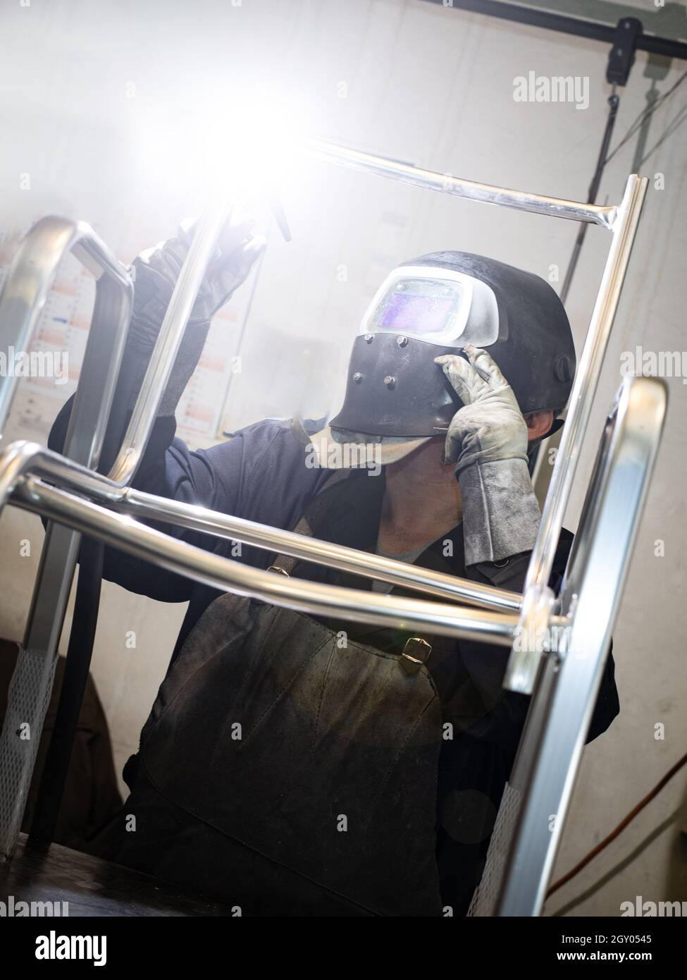 Welder erecting technical steel in a manufacturing factory. Metalwork ...