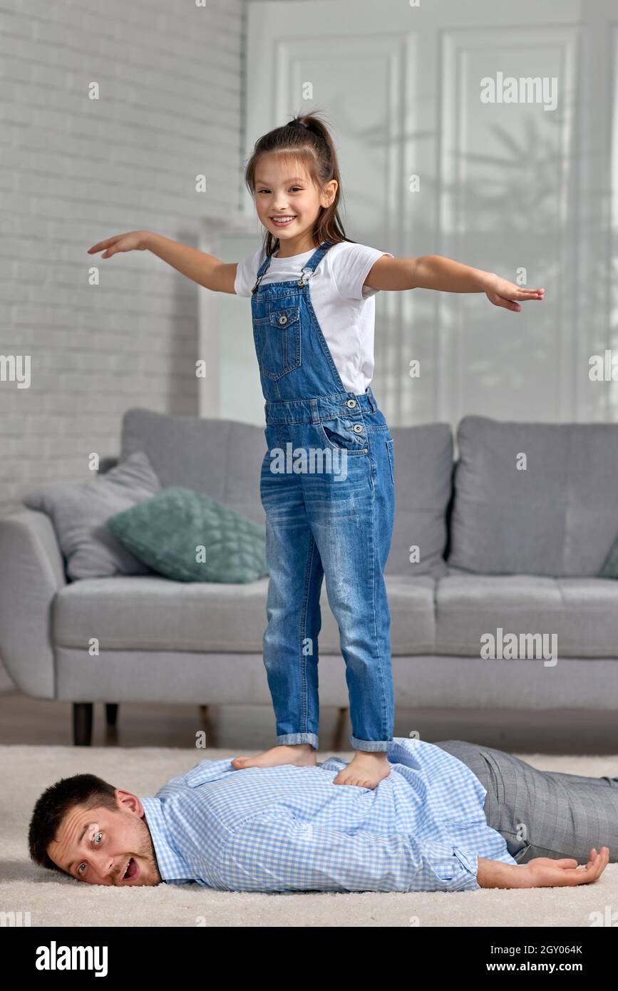 happy little child daughter doing massage to father at home. Father's ...