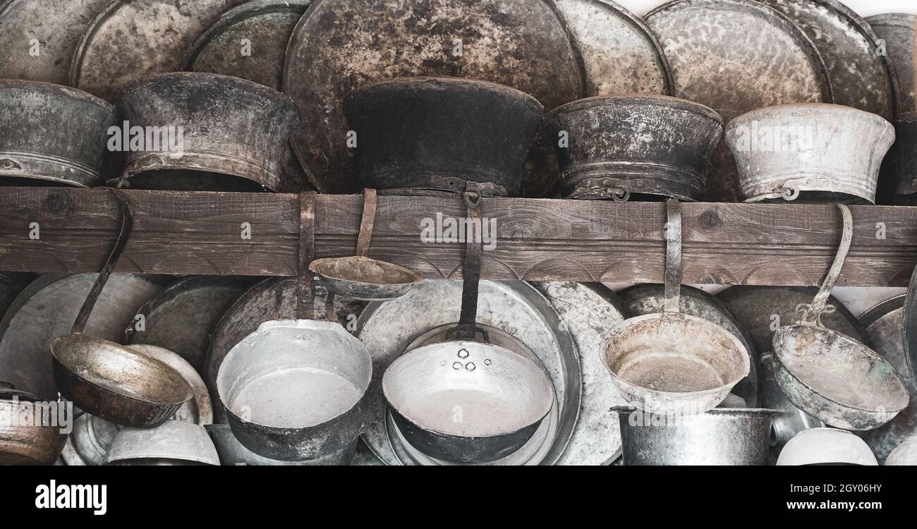 collection of old metal pan pot and kitchenware hanging on the wall in ...
