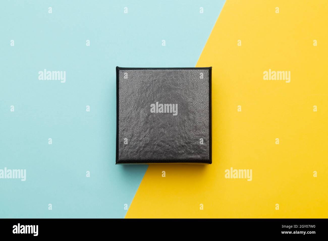 Mini black box product packaging isolated on yellow half blue ...