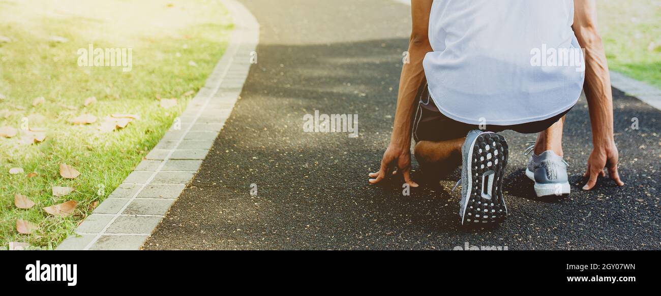 Athlete men in running start pose at walking way in public park ...