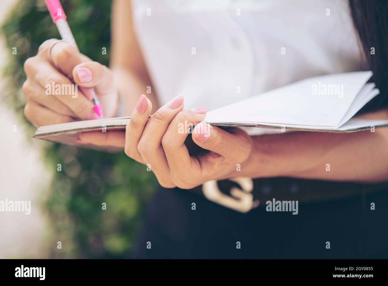 Woman writing down her thoughts in the notebook. girl is writing notes ...