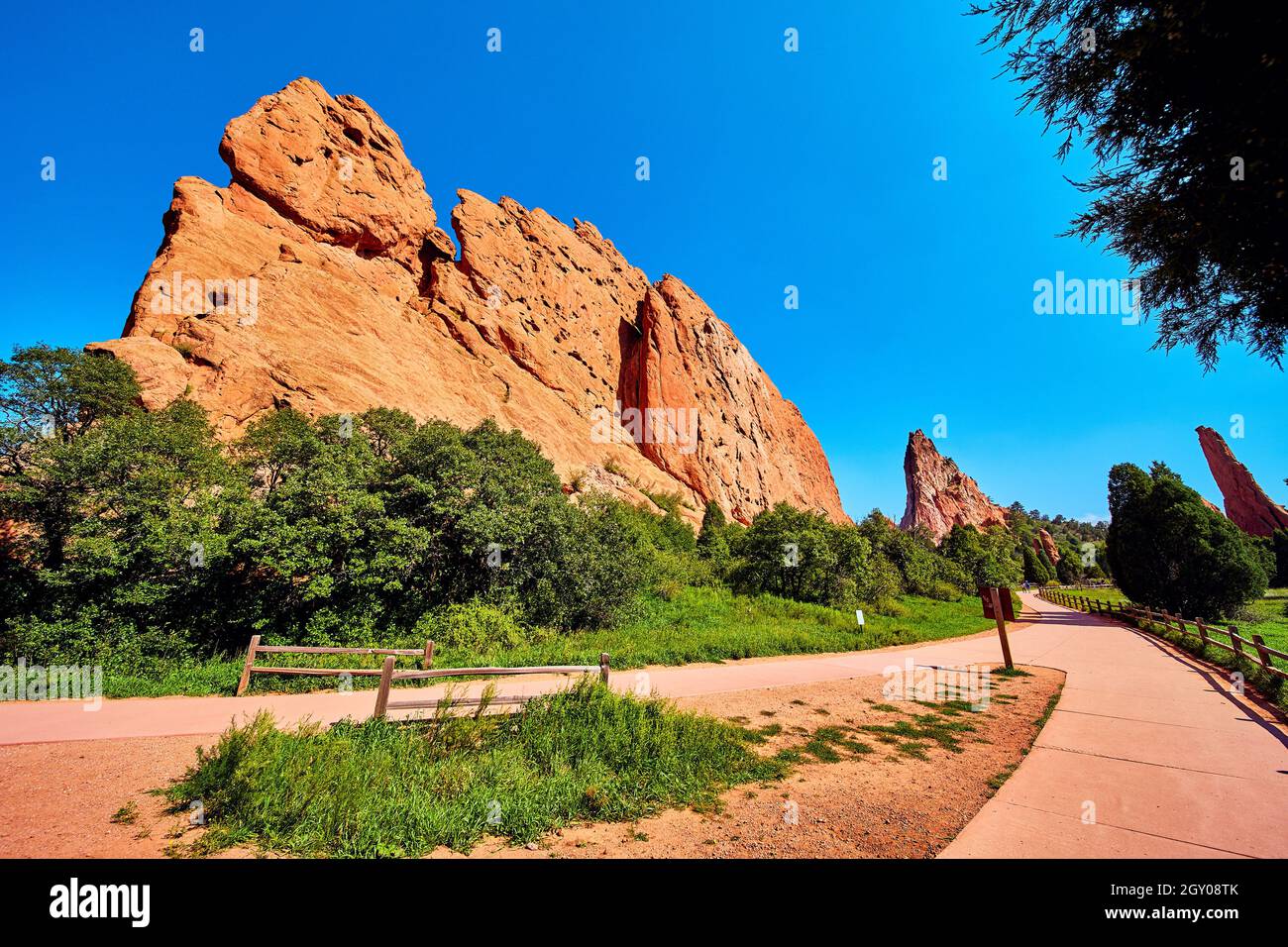 Walking path next to large mountain of red rock pillars Stock Photo - Alamy