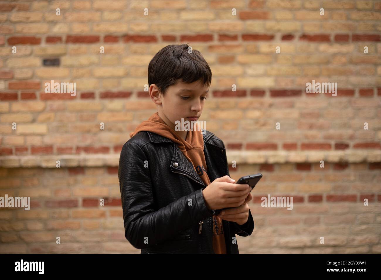 Photo of teenage boy aged 11-12 using smart phone against background of ...
