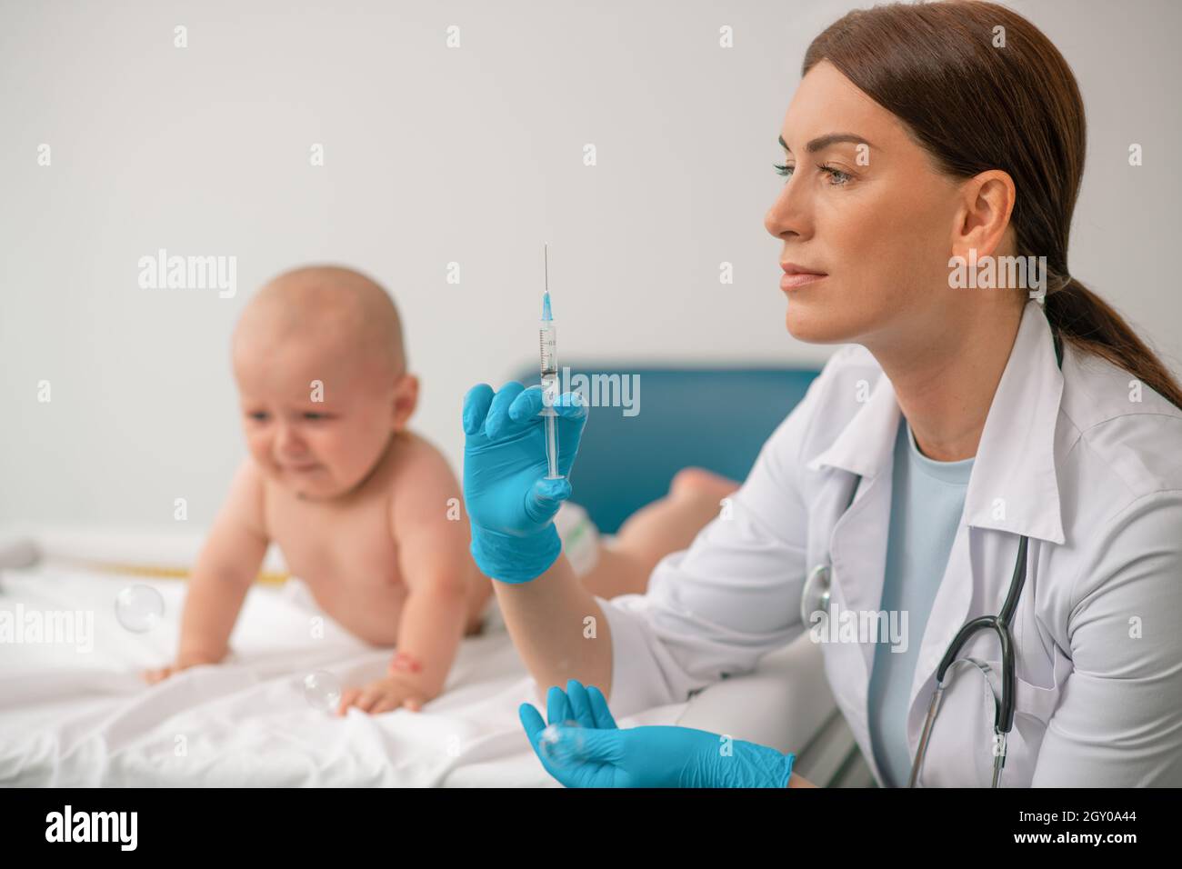 Doctor preparing to give an injection to a newborn Stock Photo - Alamy