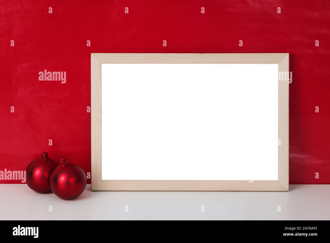 Blank wooden photo frame mockup template and christmas balls on red ...