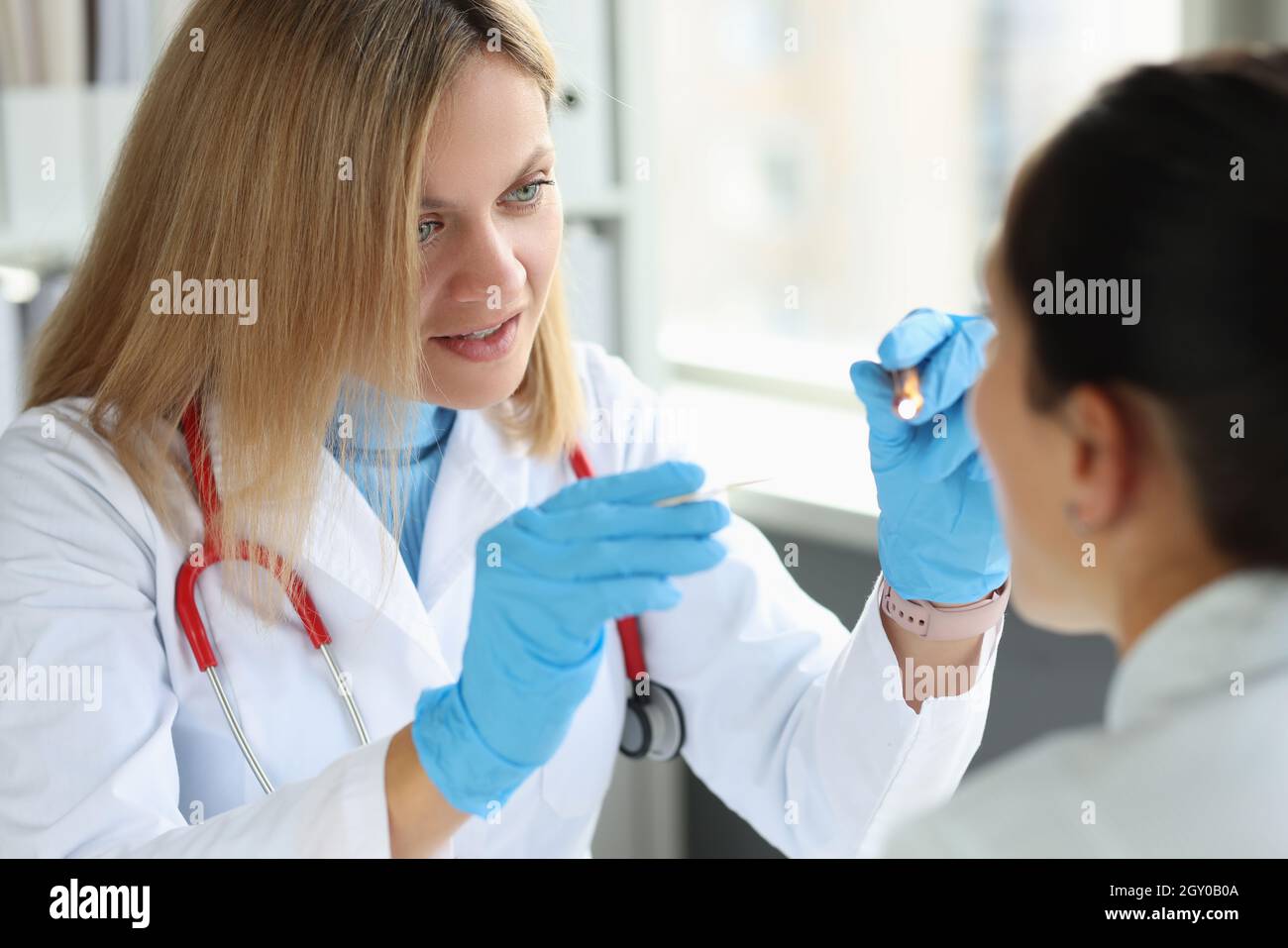 Female ENT doctor examines patient throat closeup Stock Photo - Alamy