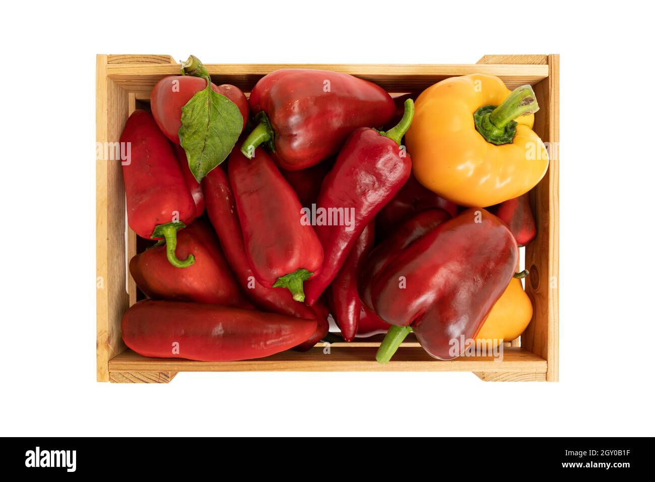 red and yellow peppers in wooden crate isolated on white background ...
