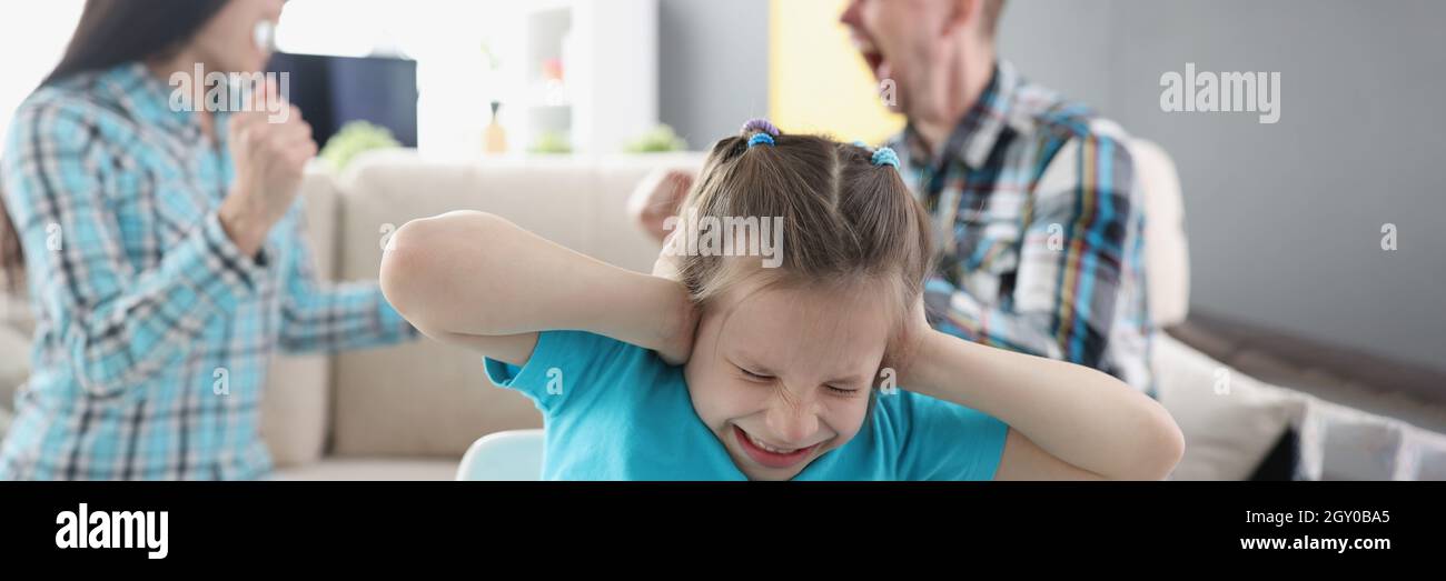 Little girl closing her ears against background of swearing parents at ...