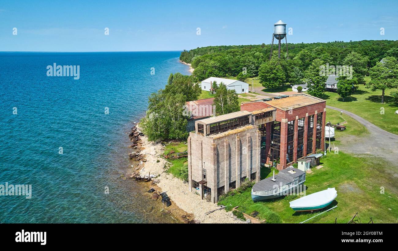 Aerial of old abandoned brick and cement building and water tower on ...