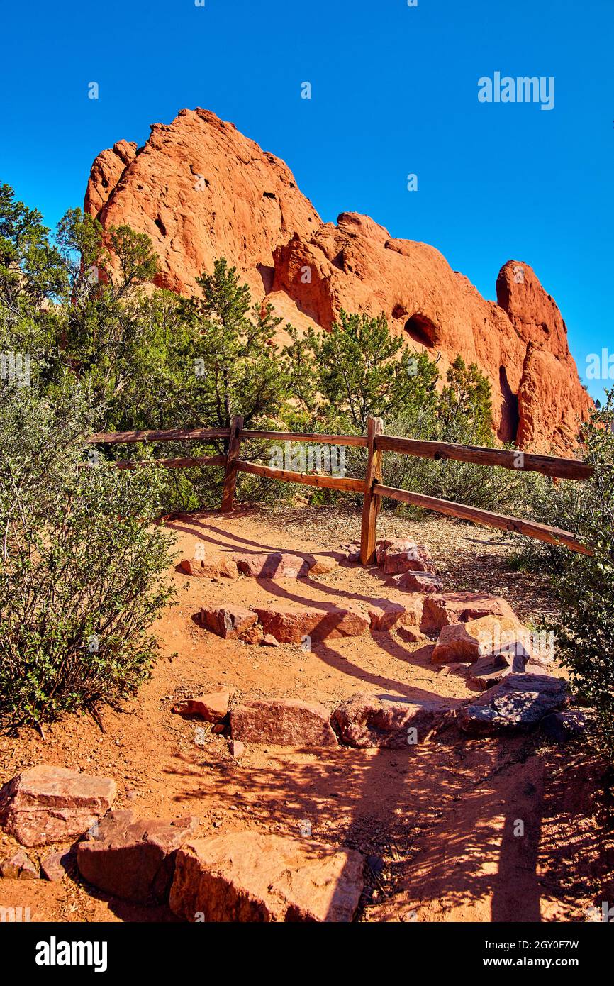Stone steps in desert path with wood fence and large red rocks against ...