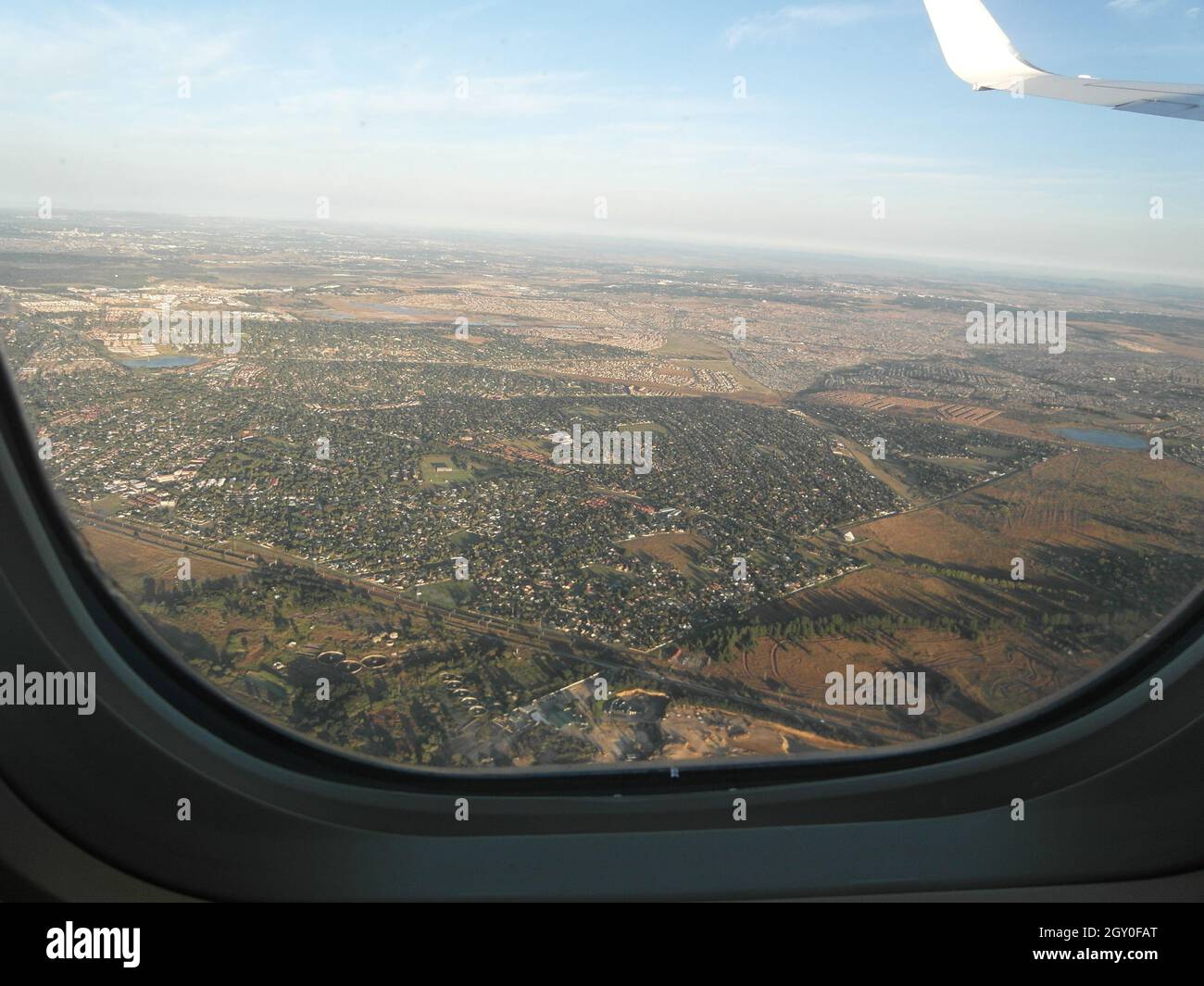 View from an airplane window over a city suburb on landing approach to ...