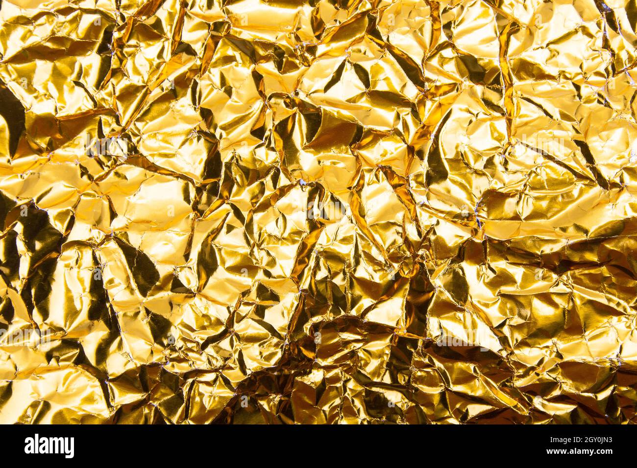 Gold crumpled foil paper texture background Stock Photo - Alamy