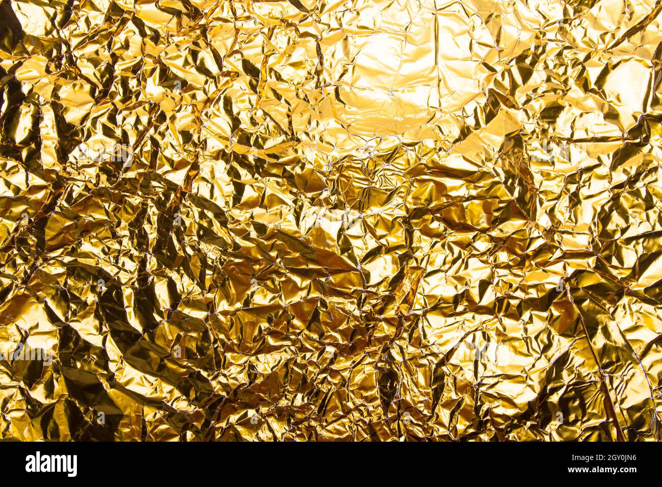 Gold crumpled foil paper texture background Stock Photo - Alamy