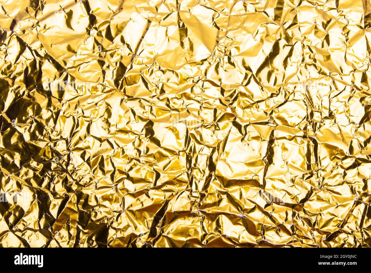 Gold crumpled foil paper texture background Stock Photo - Alamy