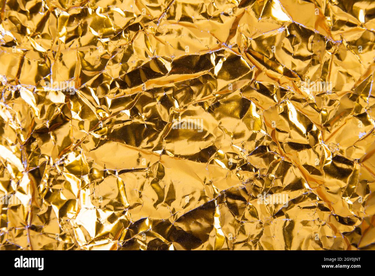 Gold crumpled foil paper texture background Stock Photo - Alamy
