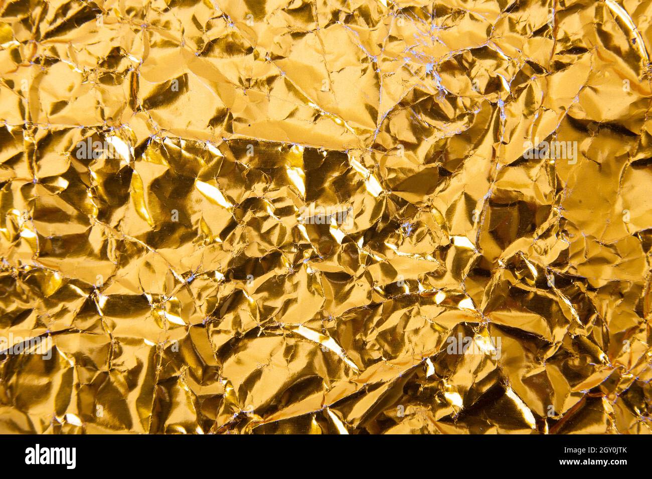 Gold crumpled foil paper texture background Stock Photo - Alamy