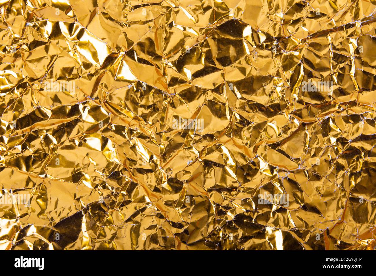 Gold crumpled foil paper texture background Stock Photo - Alamy