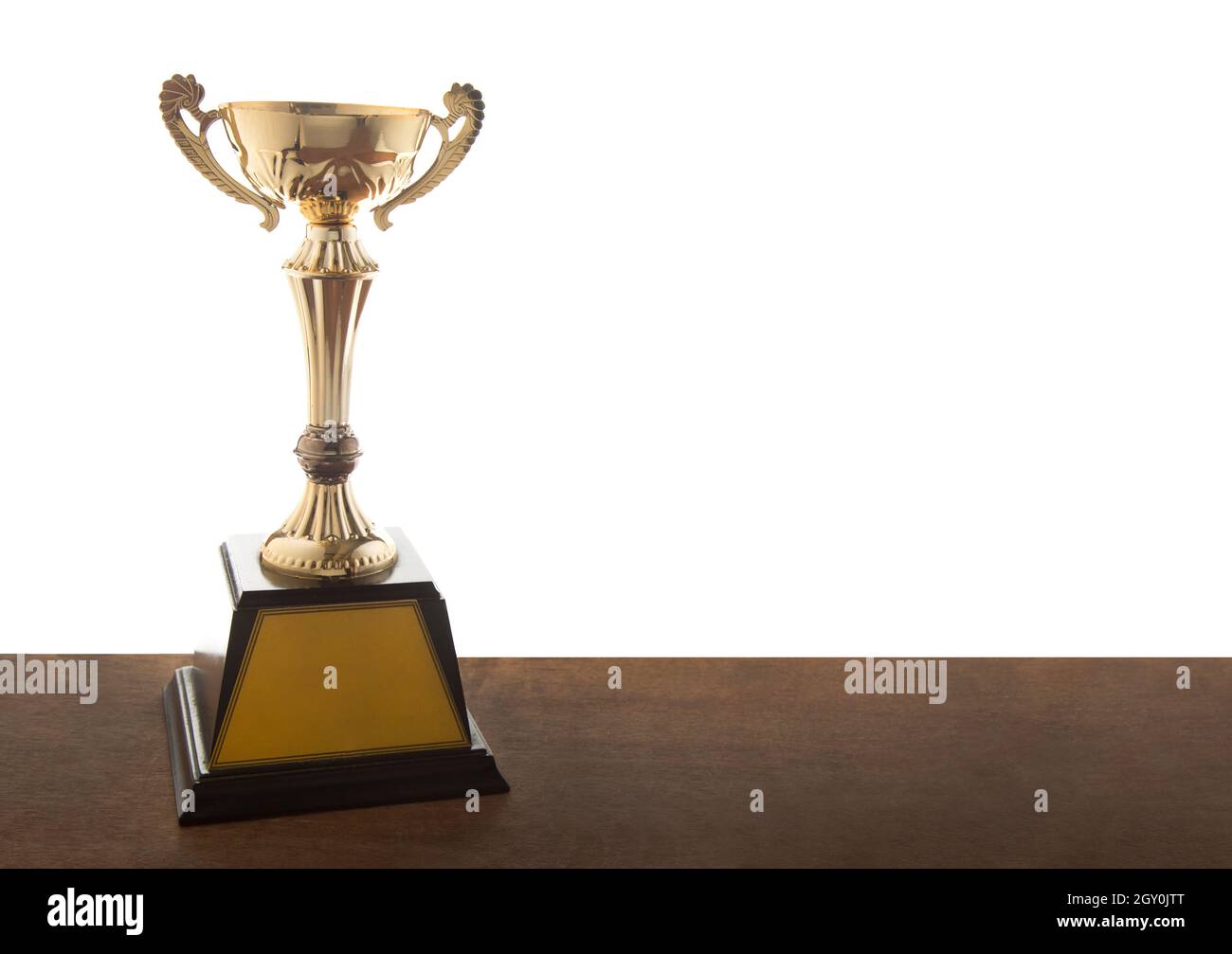 Gold trophy on wooden table isolated over white background. Winning ...