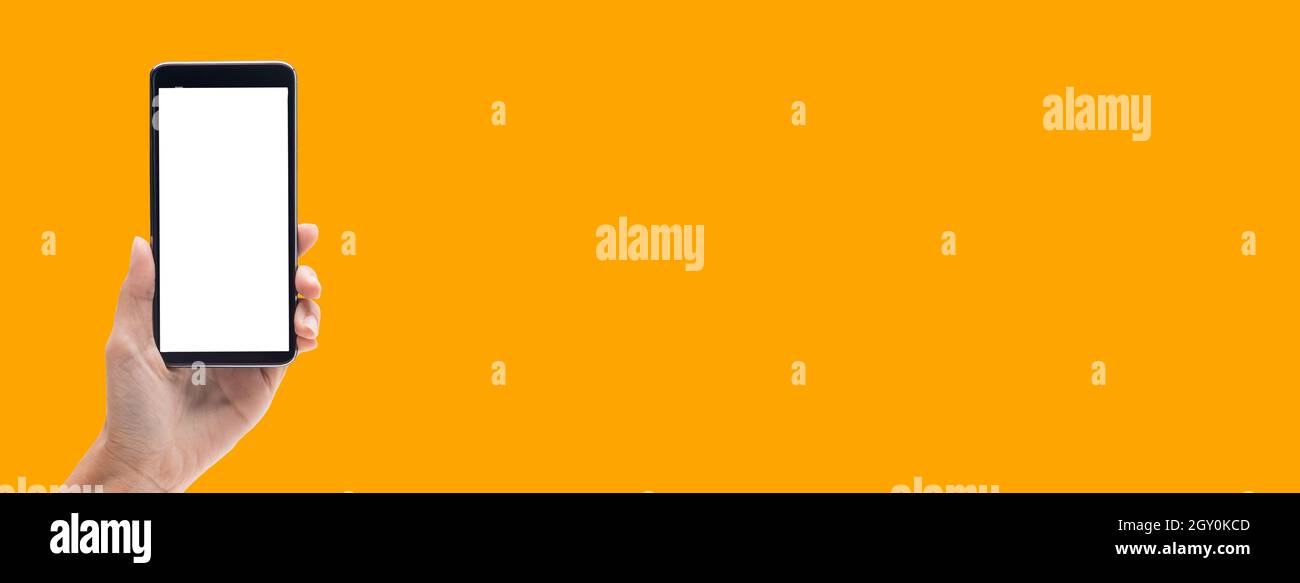 Hand holding the black smartphone on colorful orange banner background ...