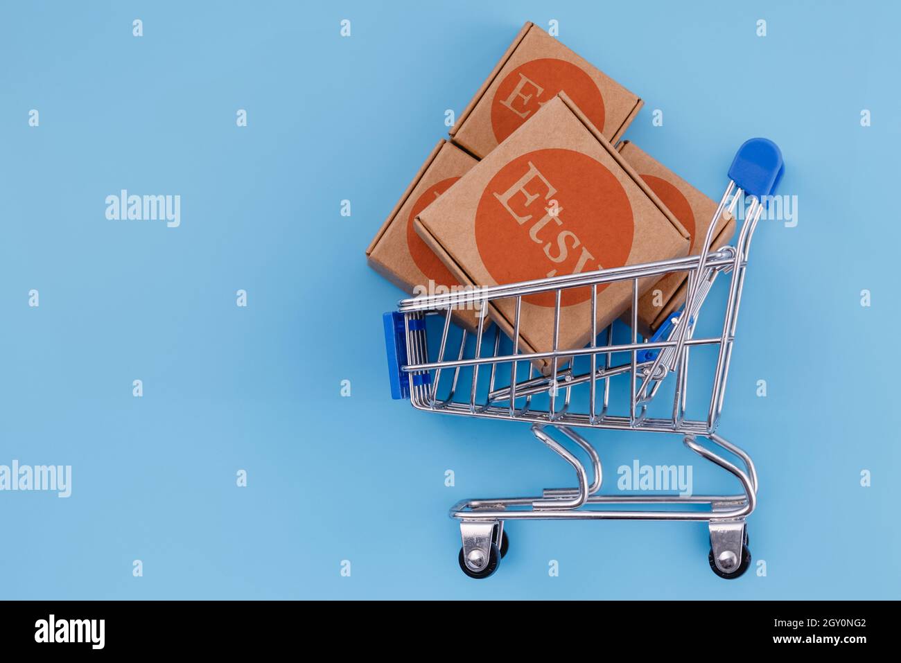 Modified photo of parcel with Etsy logo in the shopping cart on a blue ...