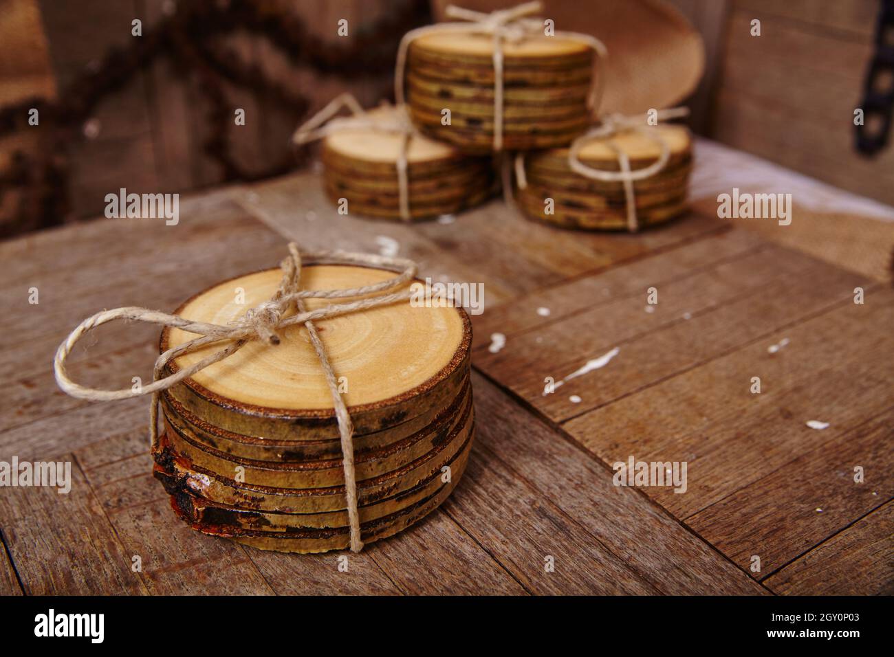 Four bundles of rustic wooden coasters on a wooden surface display ...