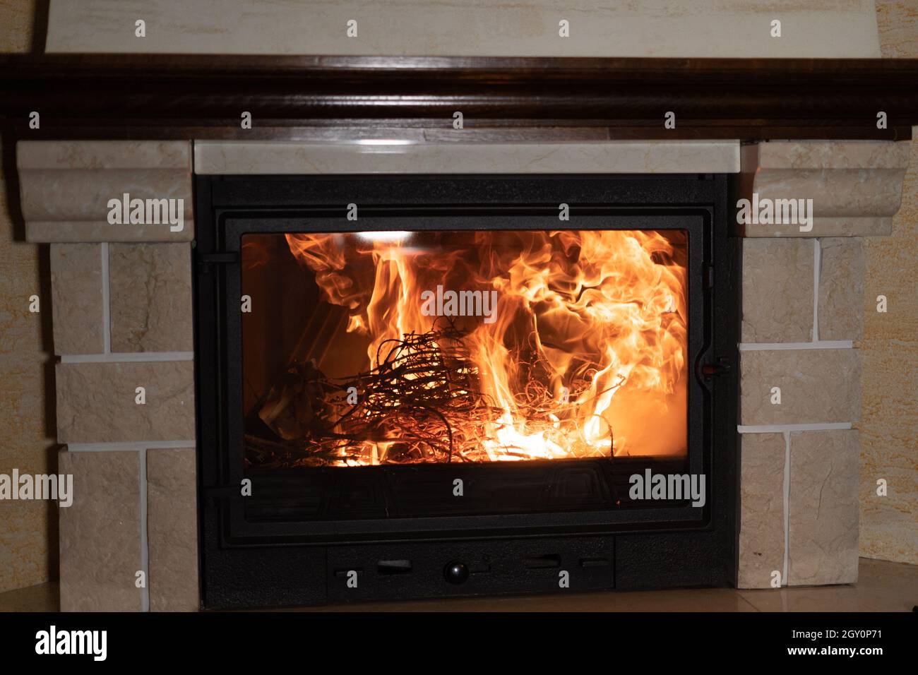 Fireplace in the interior. The firewood burns with a red flame. Home ...