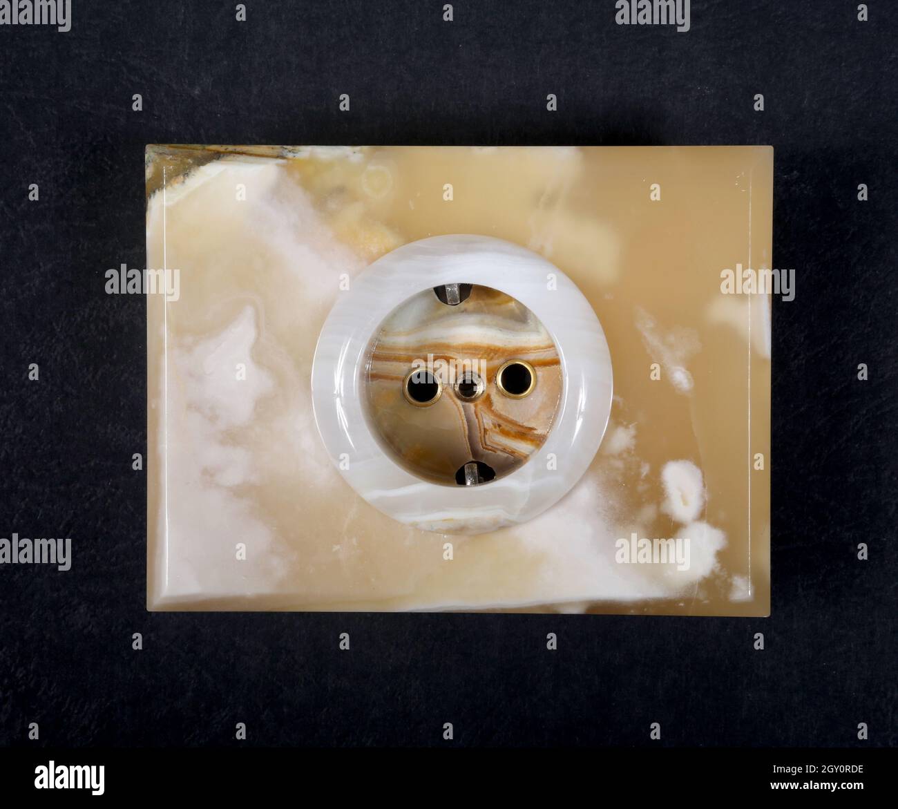 Closeup shot of a plug with a marble frame on a black background Stock ...
