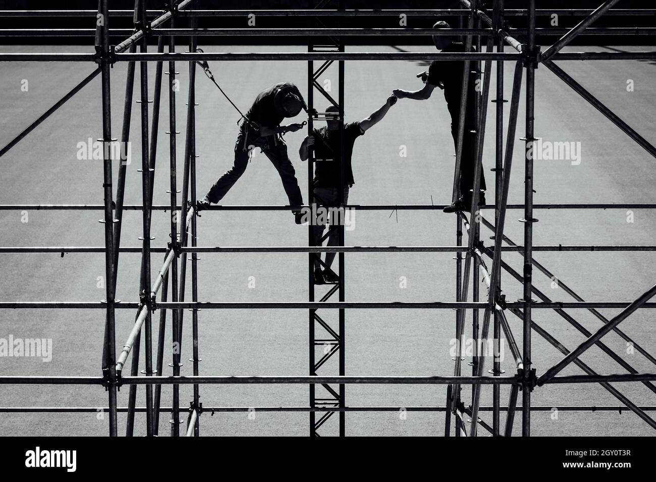 Silhouettes of three men assembling the scaffolding Stock Photo - Alamy