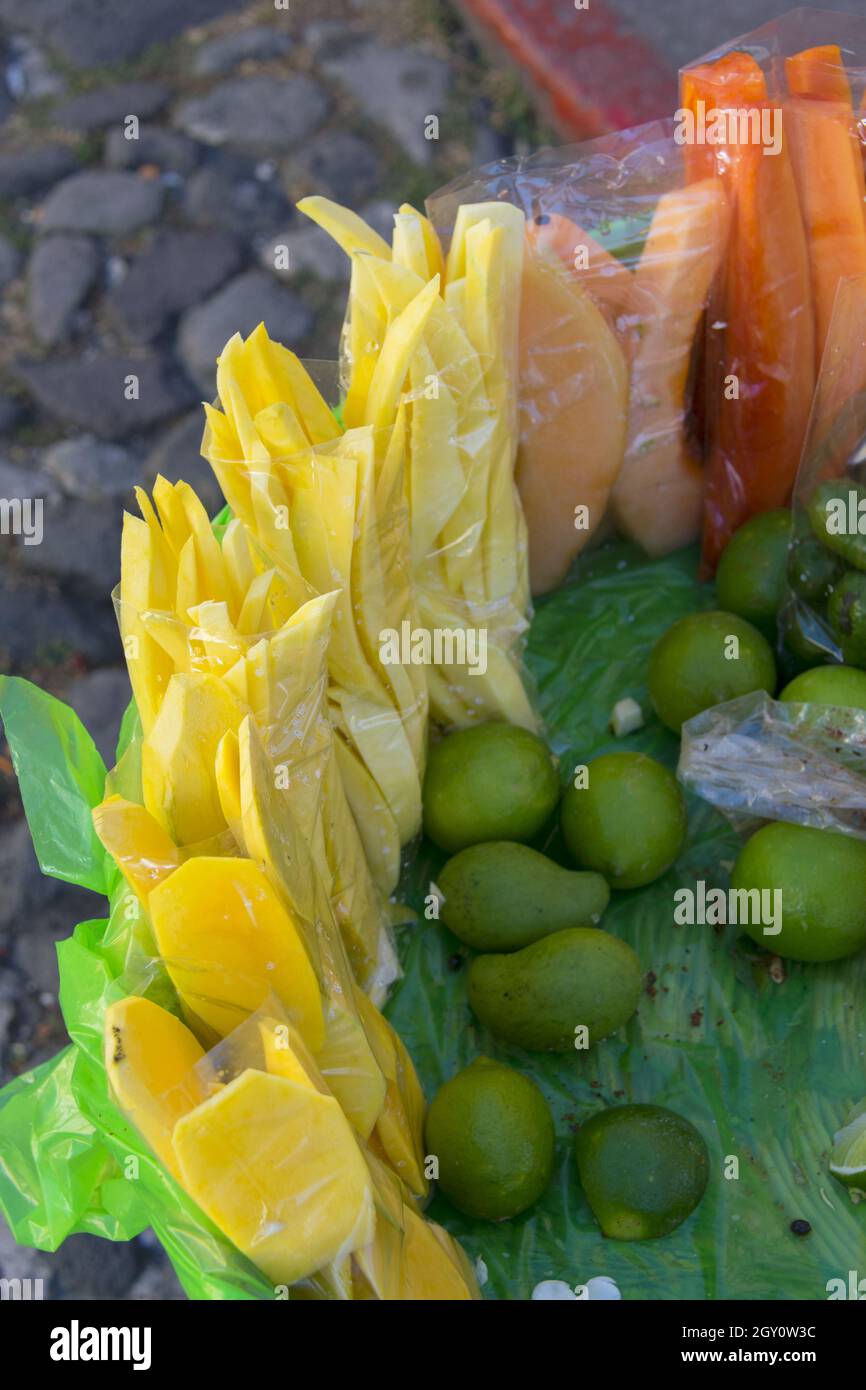 Fresh mango, fruit sliced in plastic bags in a street market. Guatemala ...