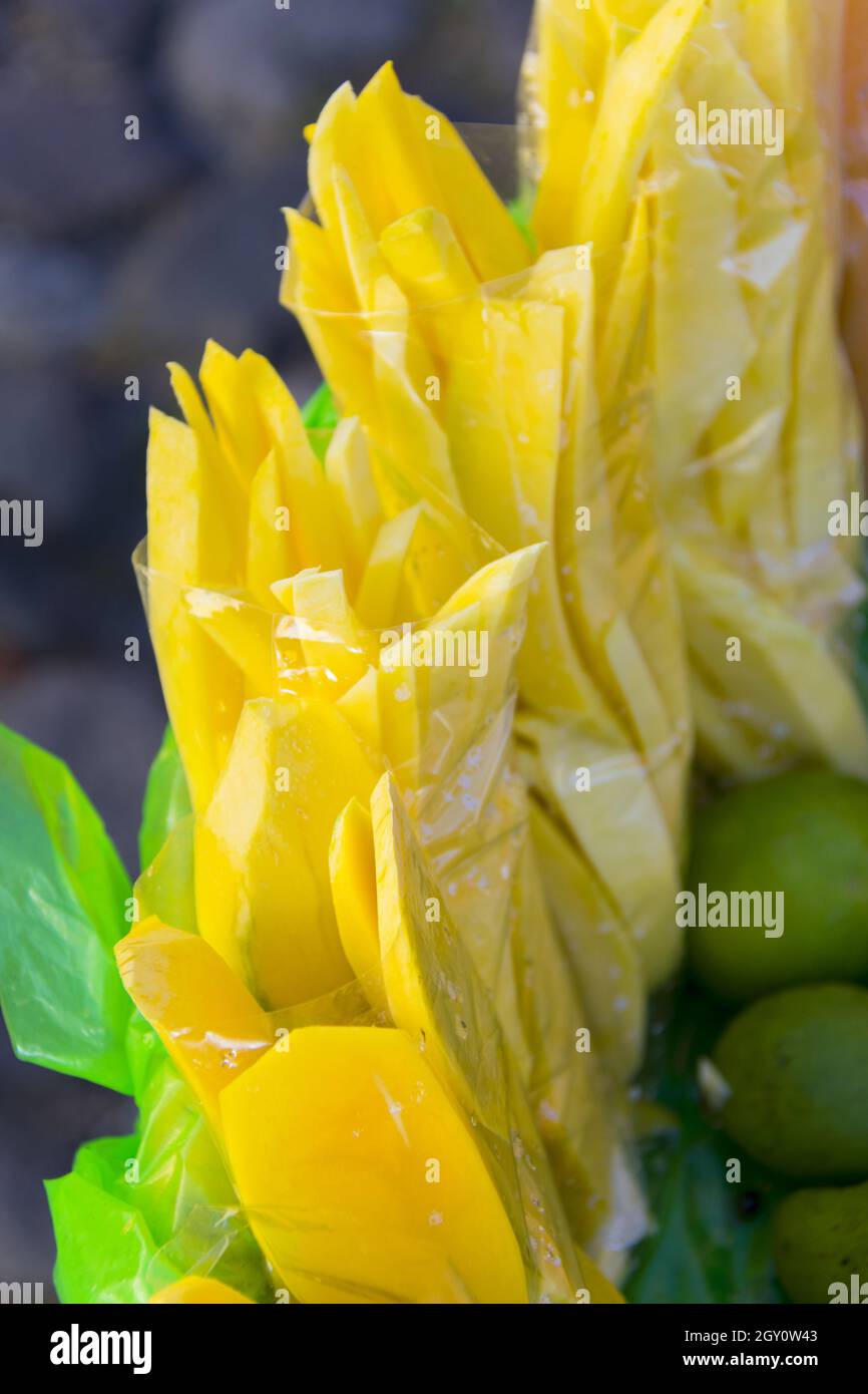 Fresh mango, fruit sliced in plastic bags in a street market. Guatemala ...