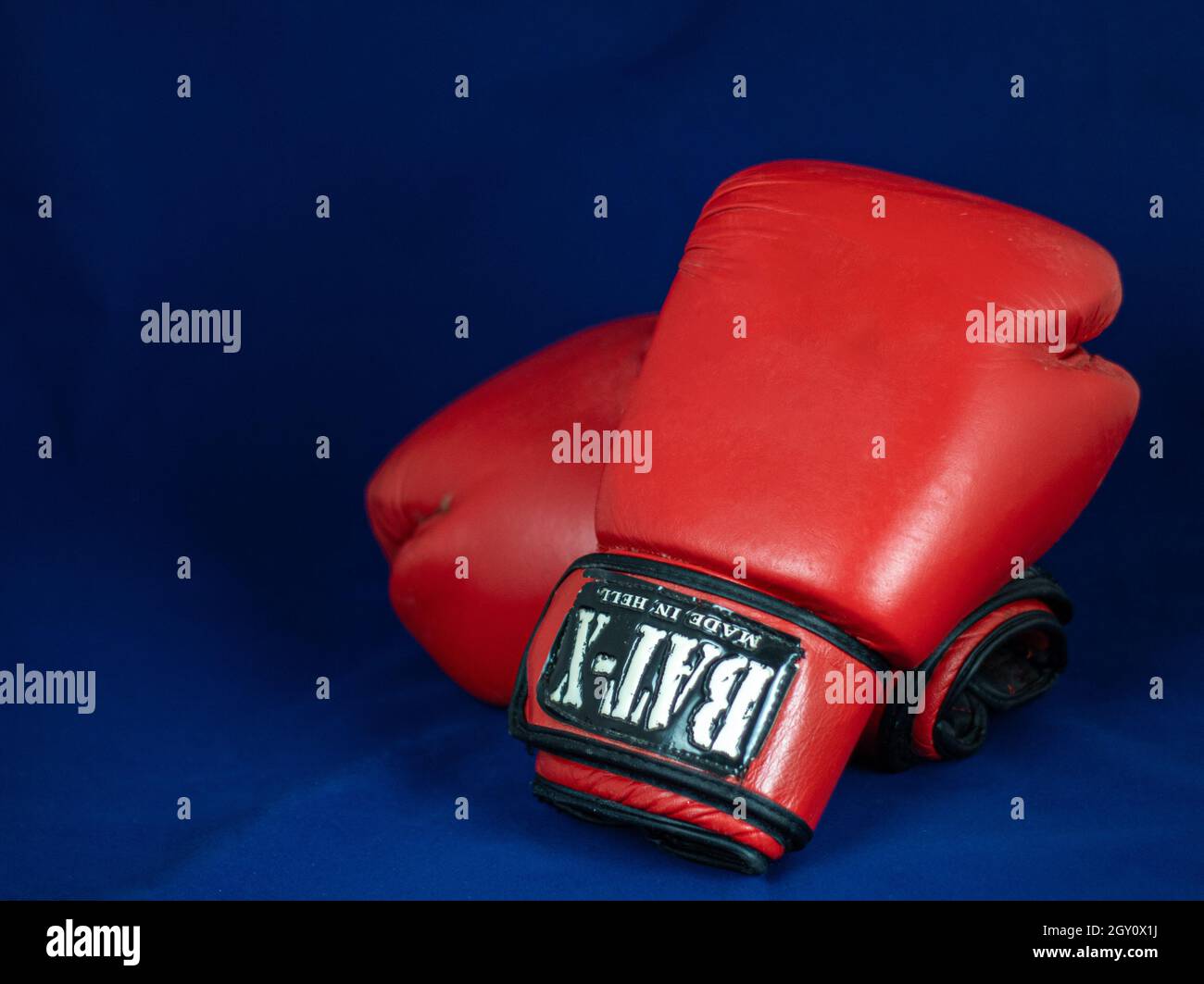 Jan 01, 1970: The red bat-X boxing gloves isolated on a blue surface ...