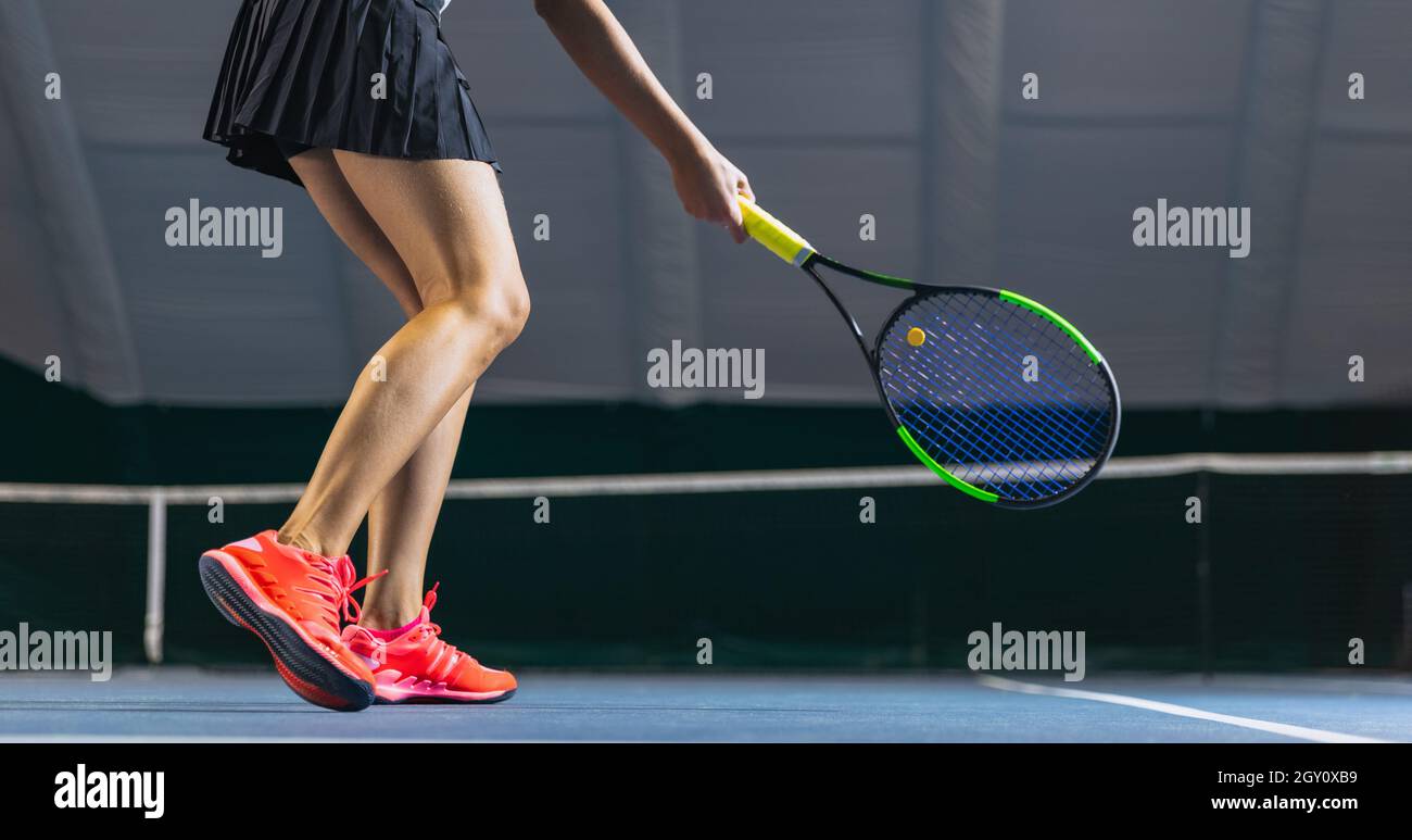 Cropped image of female tennis player in motion, legs in bright sport ...