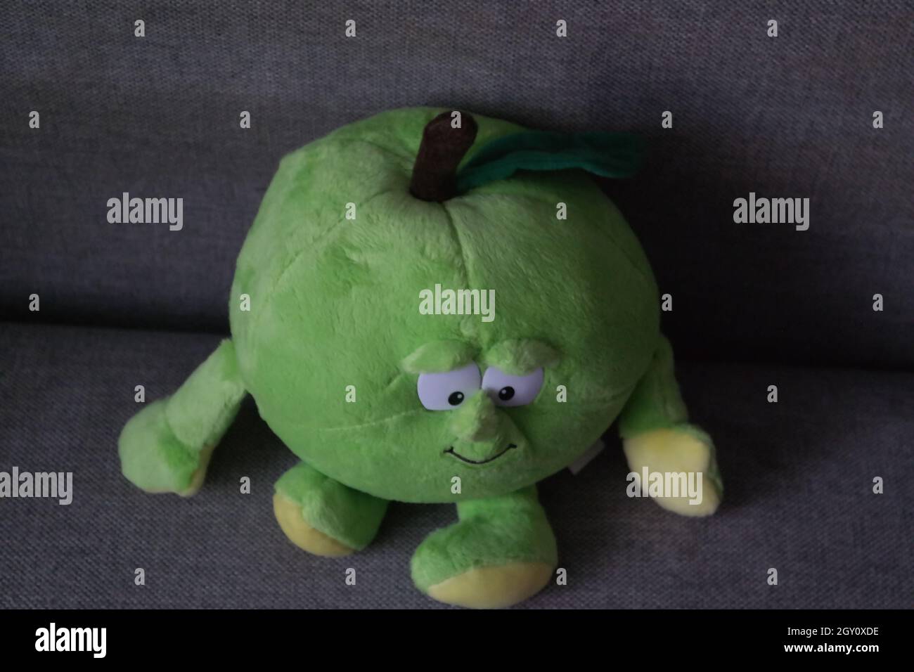 Cute green apple plush toy on the sofa Stock Photo - Alamy