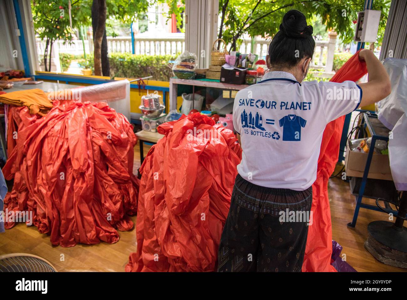 A woman is seen holding a personal protective equipment suit (PPE) for ...