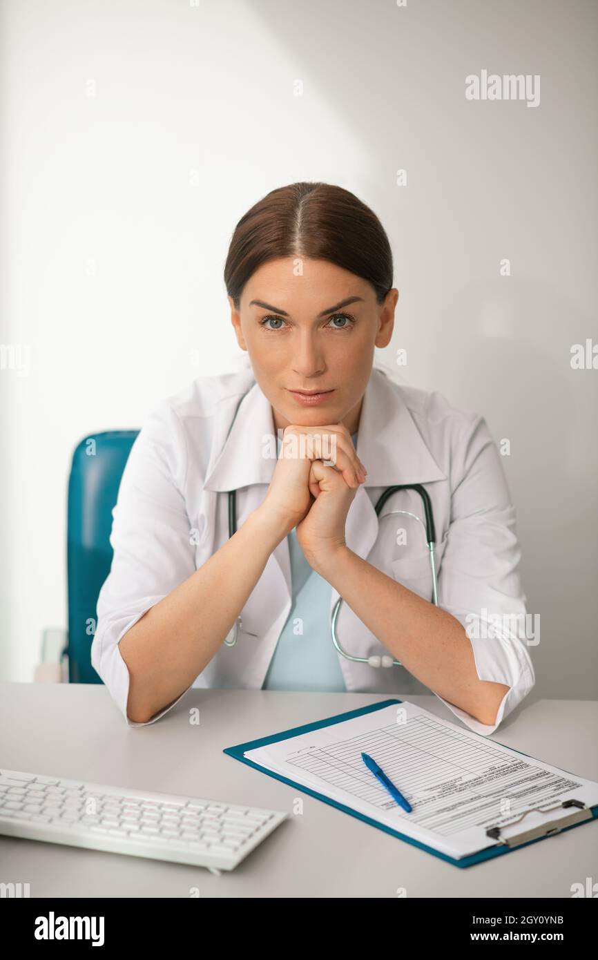 A good-looking female doctor in white robe looking thoughtful Stock ...
