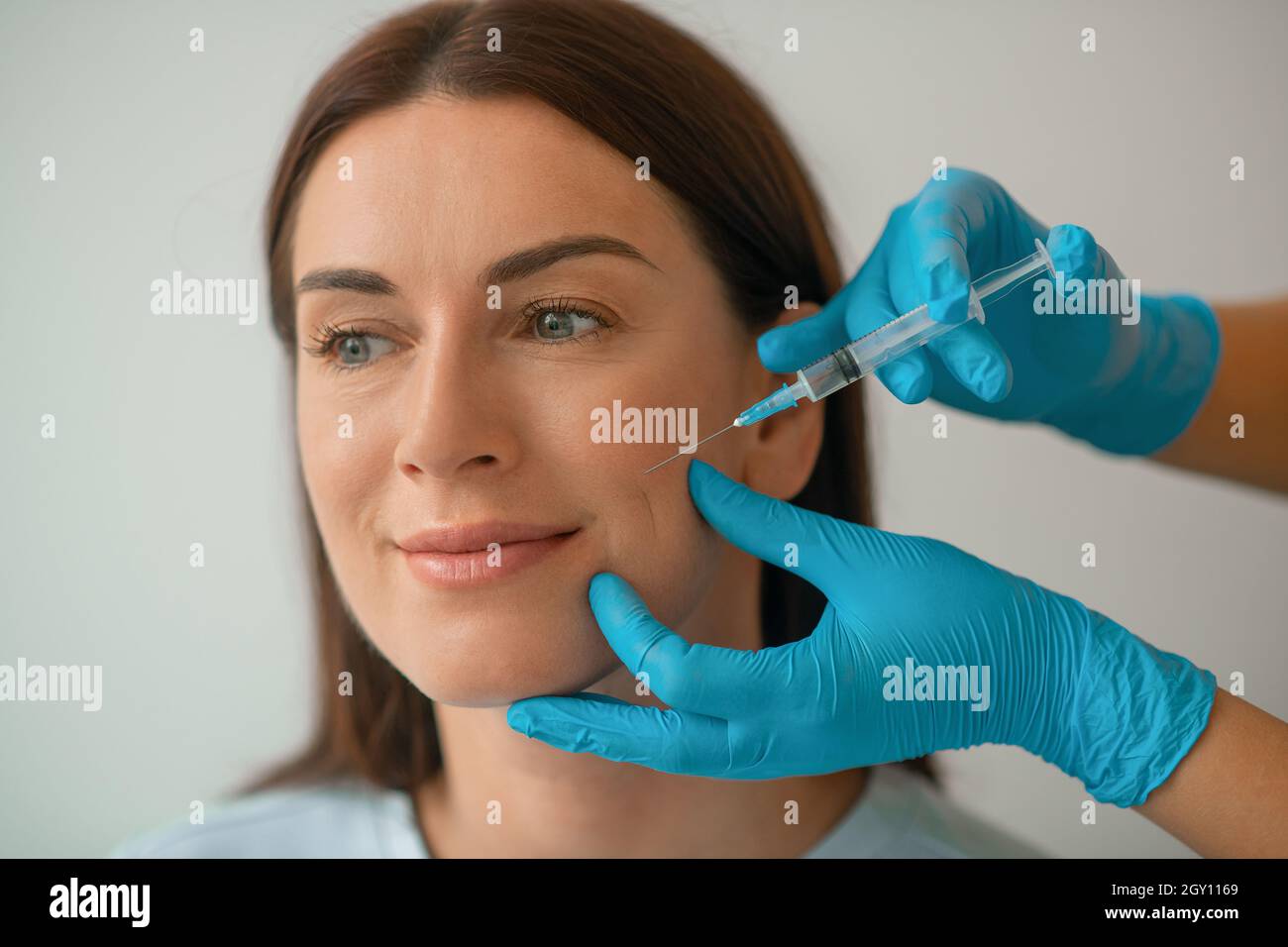 Cosmetologist injecting collagen to her clients face Stock Photo - Alamy