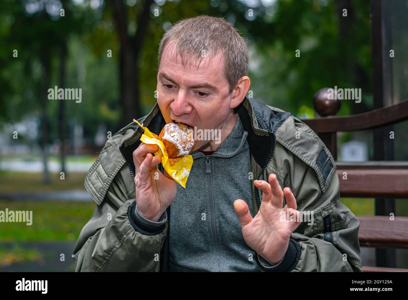 A very hungry man eats with great pleasure a delicious cupcake on the ...