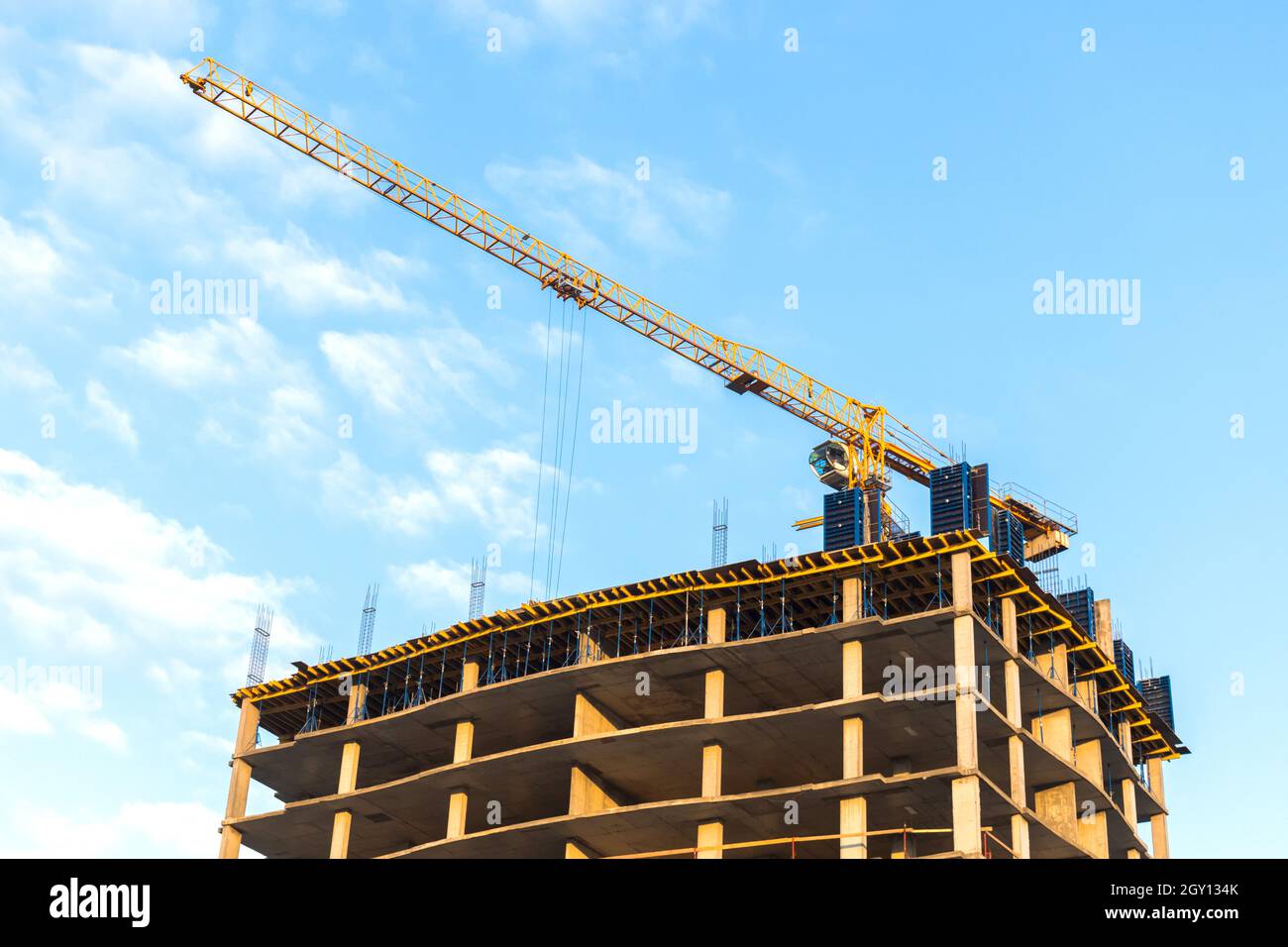 Construction tower crane on high-rise construction site, urban industry ...