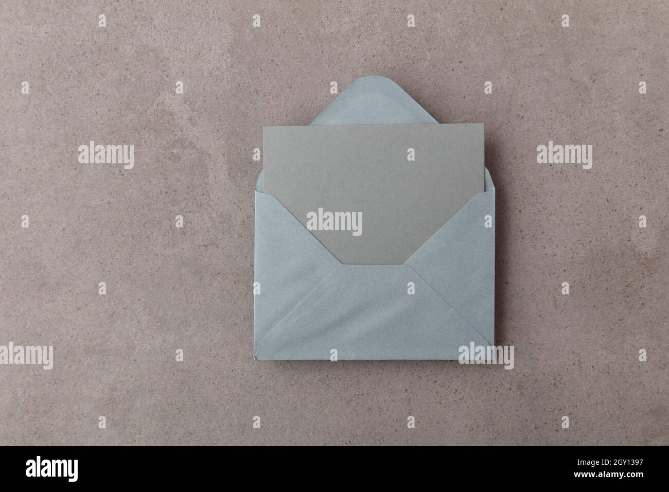 Blank grey card with grey paper envelope template mock up on a concrete ...