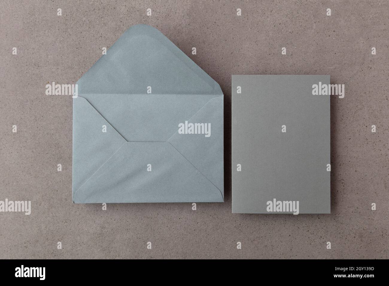 Blank grey card with grey paper envelope template mock up on a concrete ...