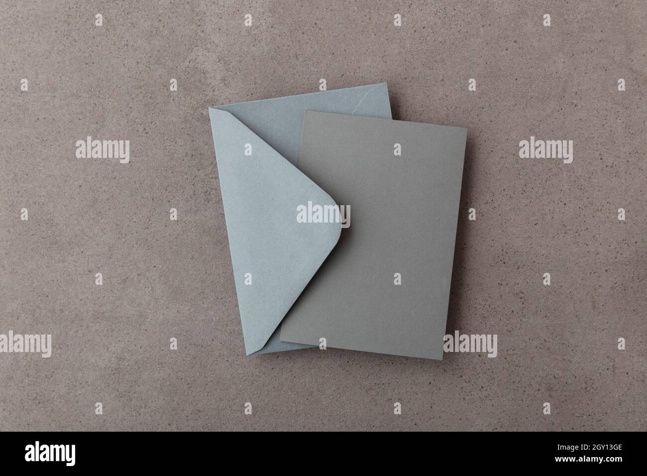 Blank grey card with grey paper envelope template mock up on a concrete ...