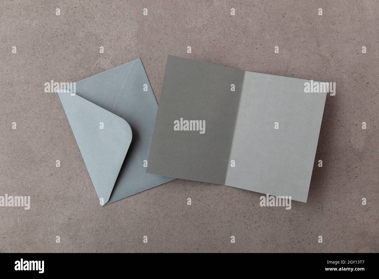Blank grey card with grey paper envelope template mock up on a concrete ...